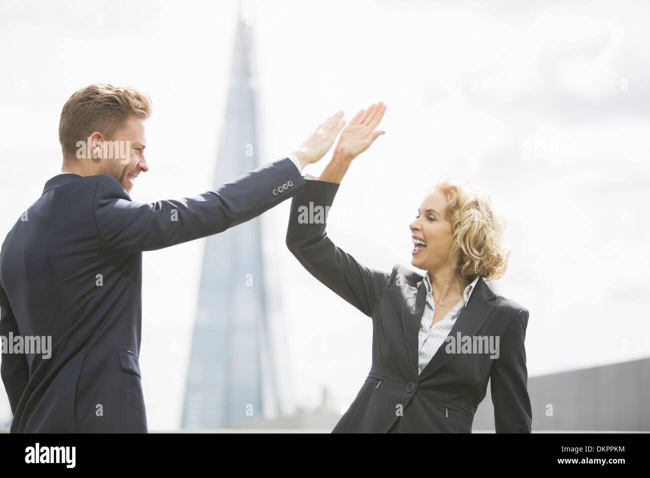 Business people high fiving outdoors Stock Photo - Alamy