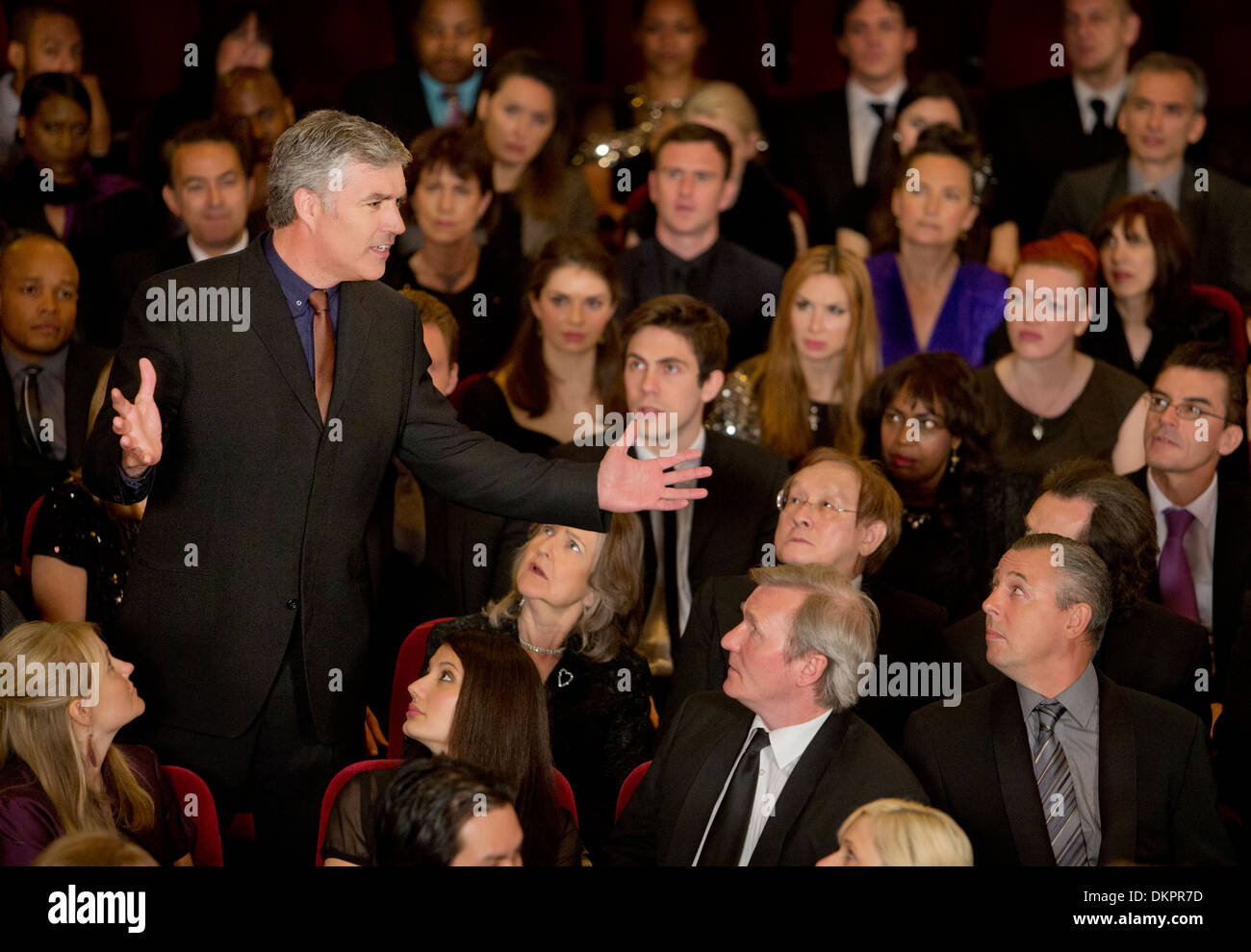 Theater audience watching standing man gesturing Stock Photo - Alamy