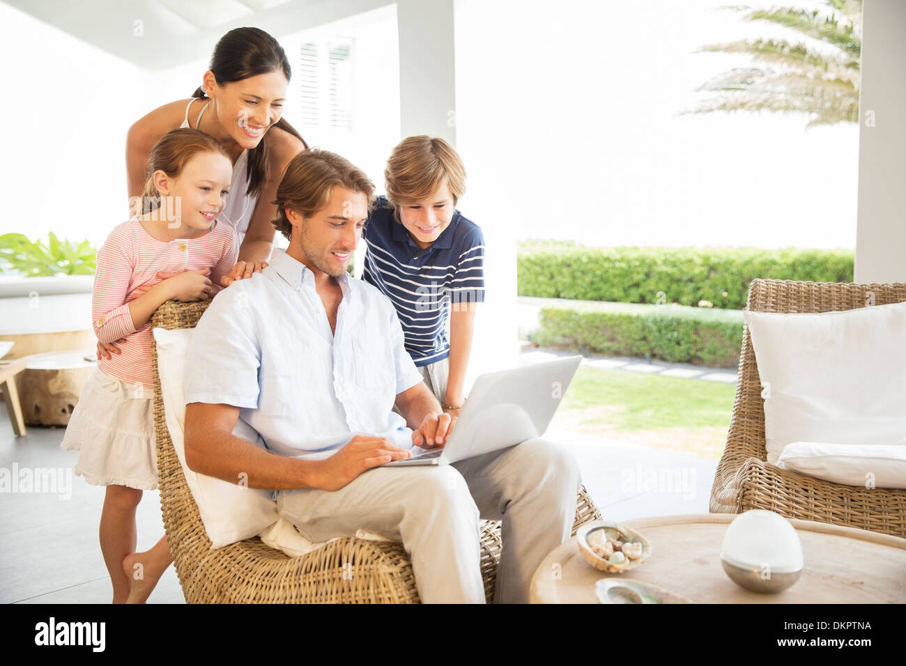 Family using laptop in living room Stock Photo - Alamy