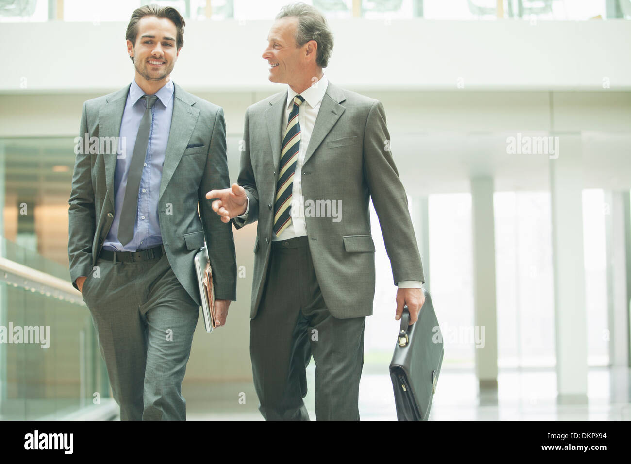 Businessmen talking in office lobby Stock Photo - Alamy
