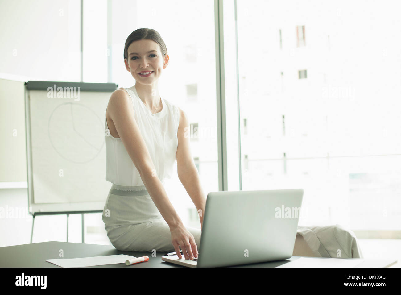 Businesswoman smiling at desk Stock Photo - Alamy