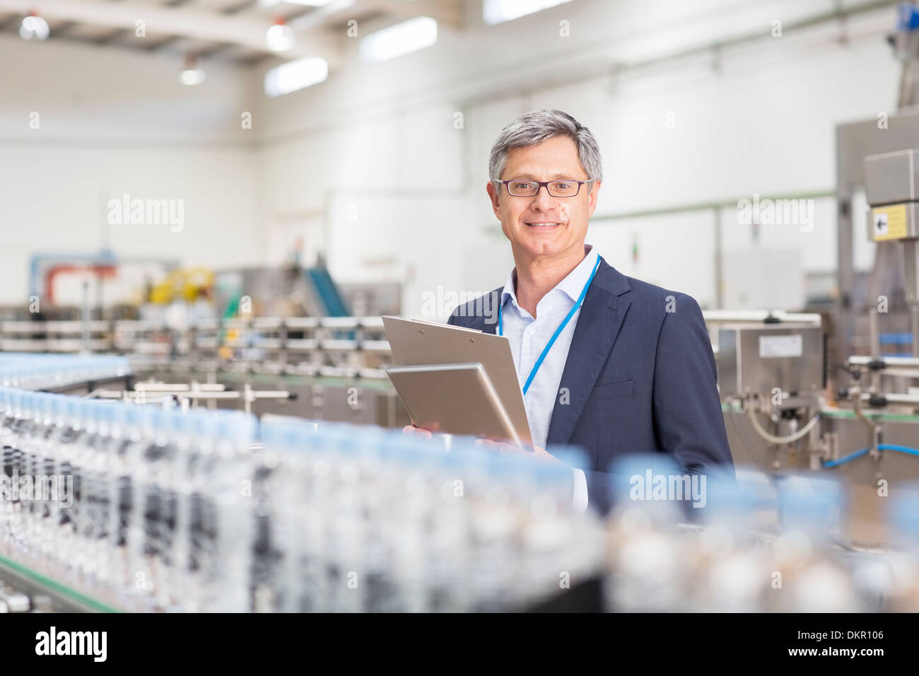 Supervisor smiling in bottling plant Stock Photo - Alamy