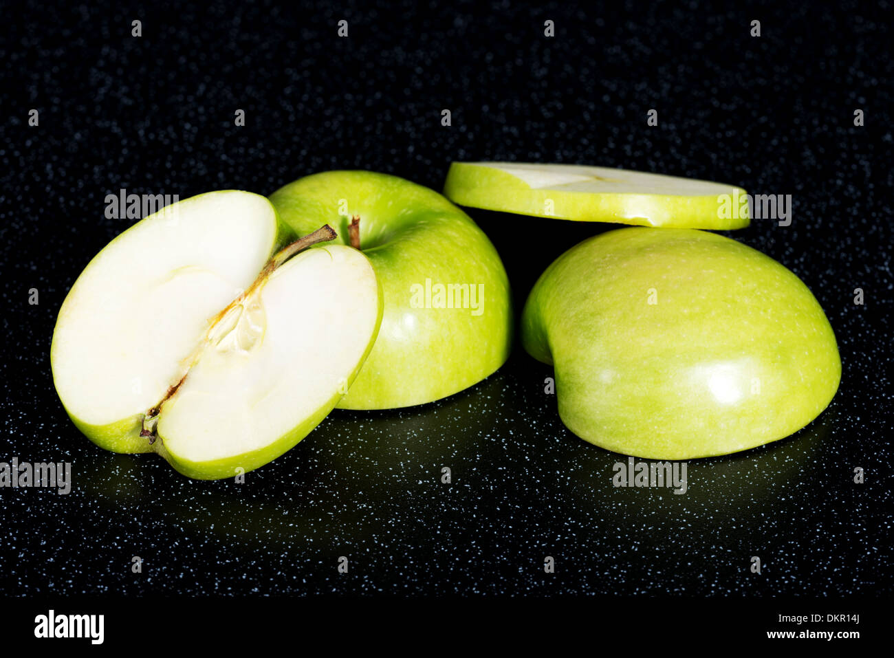 Green apples cut into two. Over black background Stock Photo - Alamy