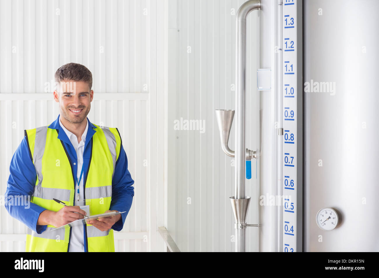 Worker smiling in factory Stock Photo - Alamy