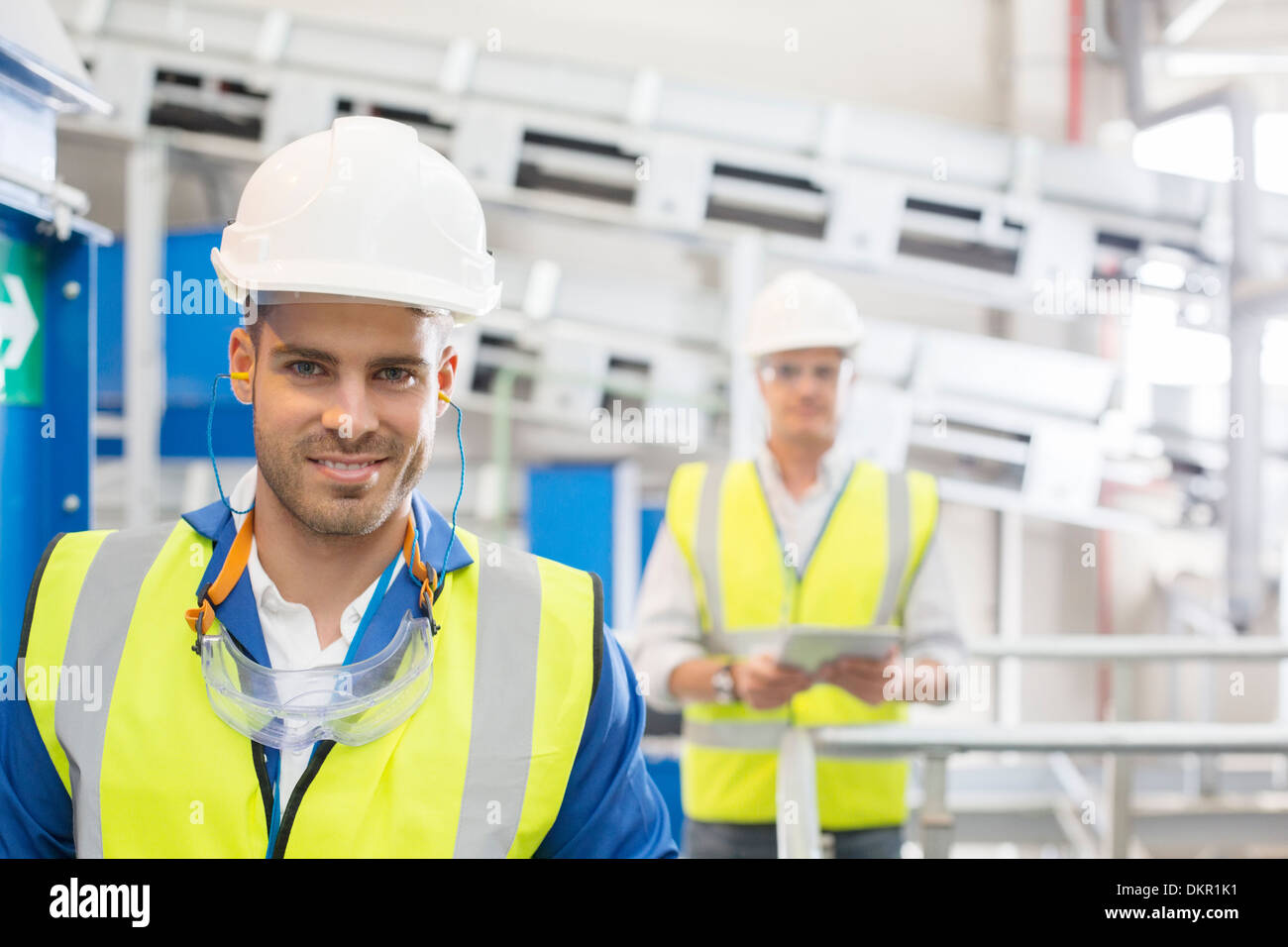 Workers smiling in factory Stock Photo - Alamy