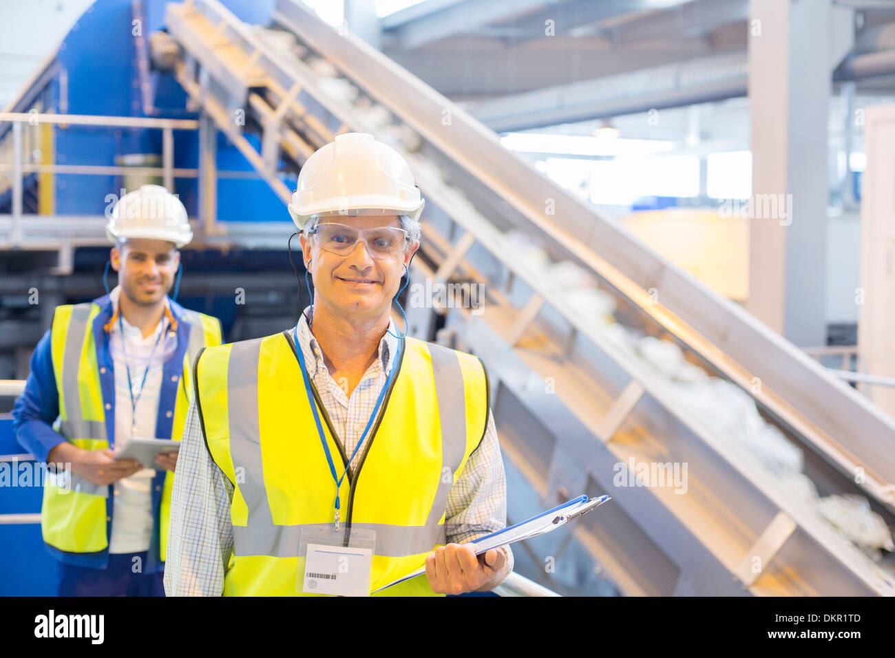 Workers smiling in recycling center Stock Photo - Alamy
