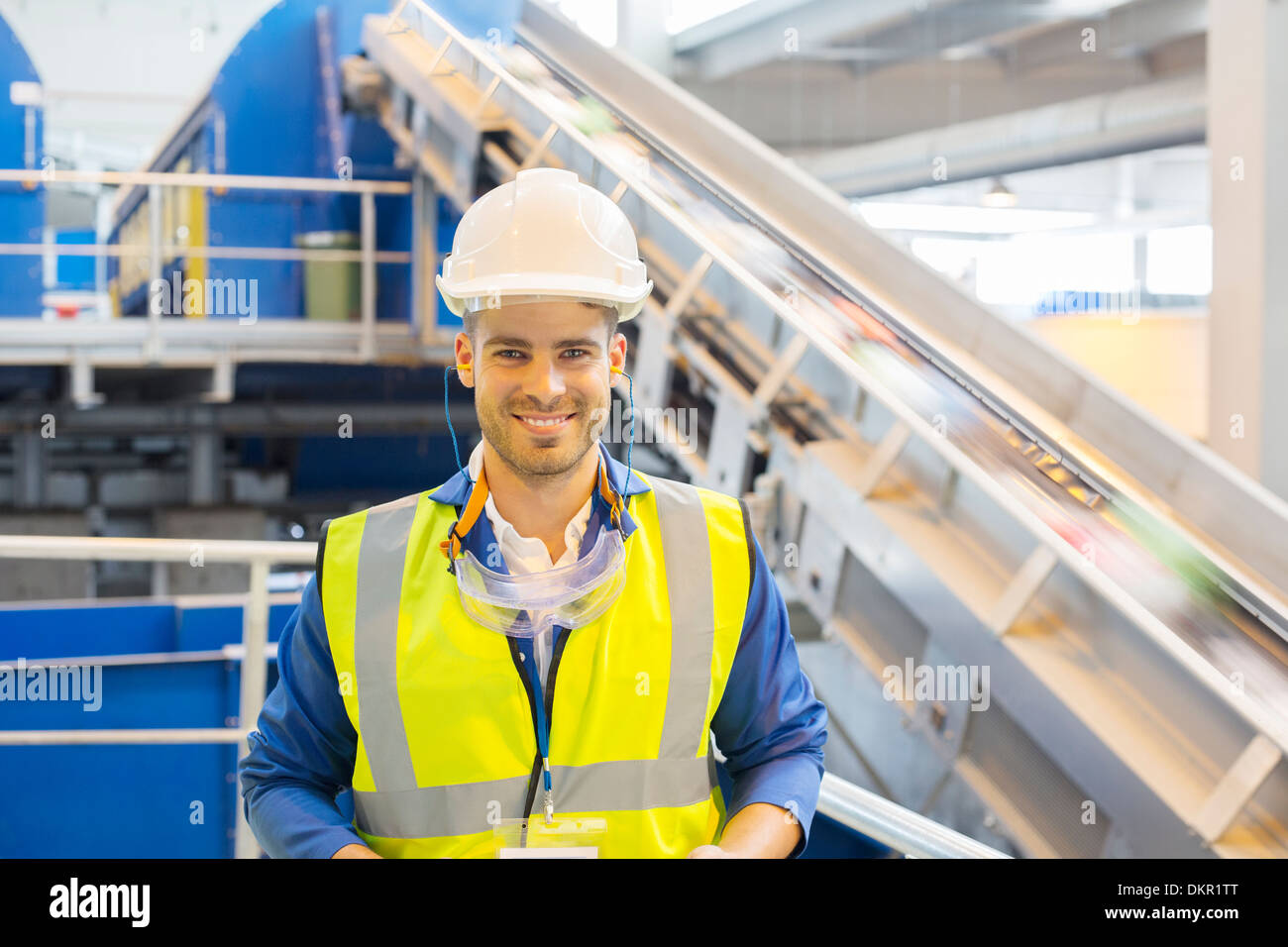 Worker smiling in recycling center Stock Photo - Alamy