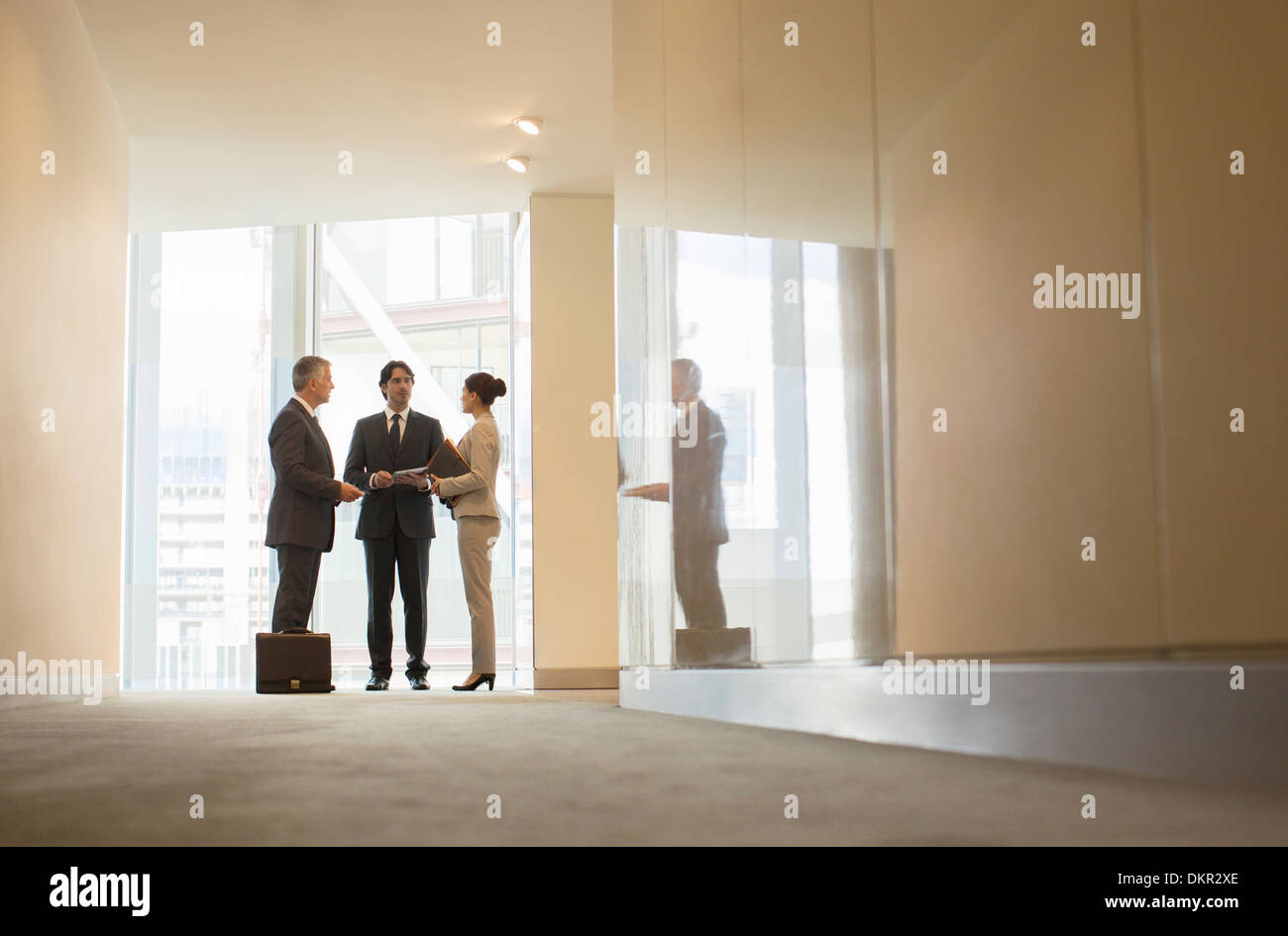 Business people talking at office window Stock Photo - Alamy