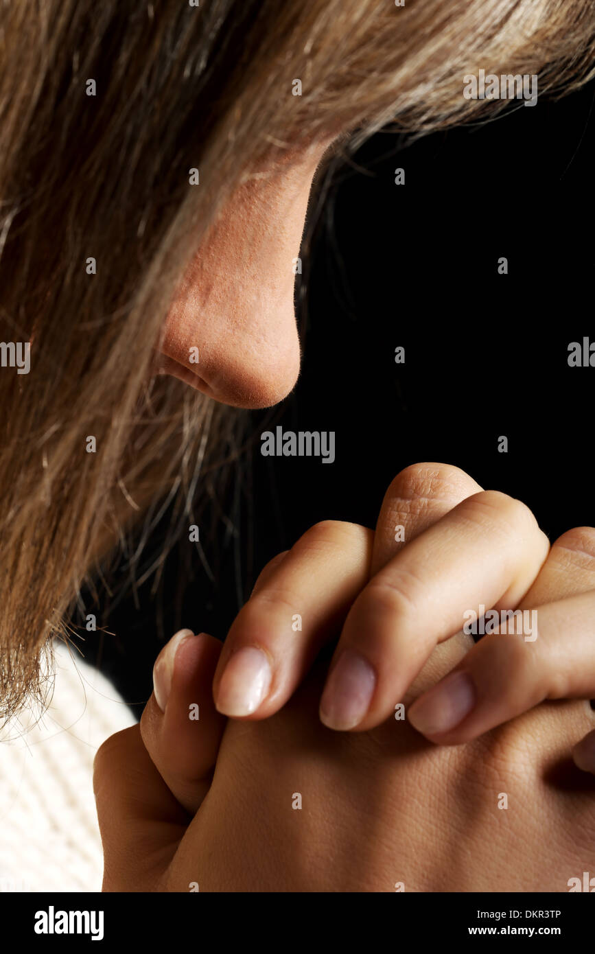 Young woman praying, close up. On black background Stock Photo - Alamy