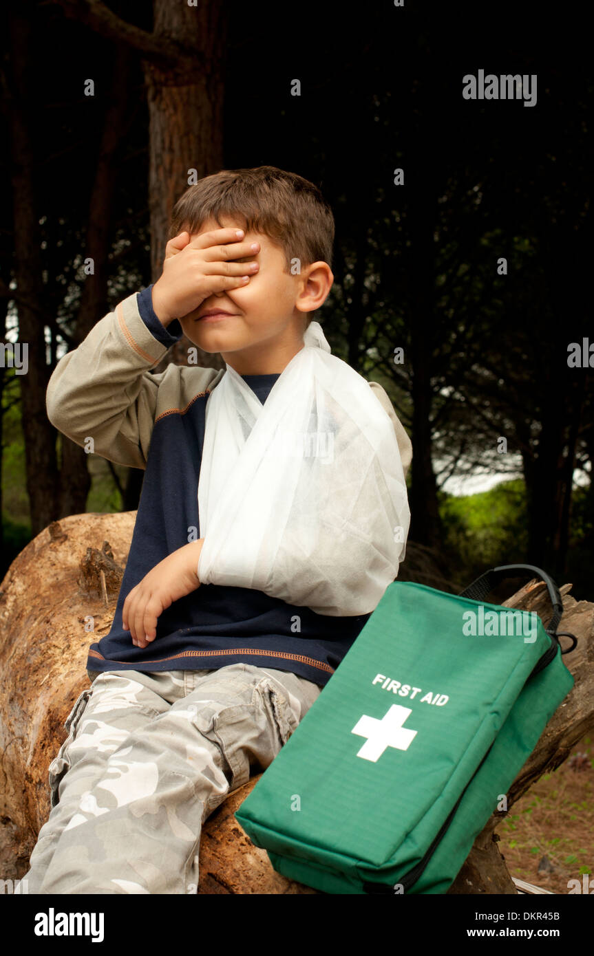 First Aid treatment given to a young boy in the forest, showing an arm ...