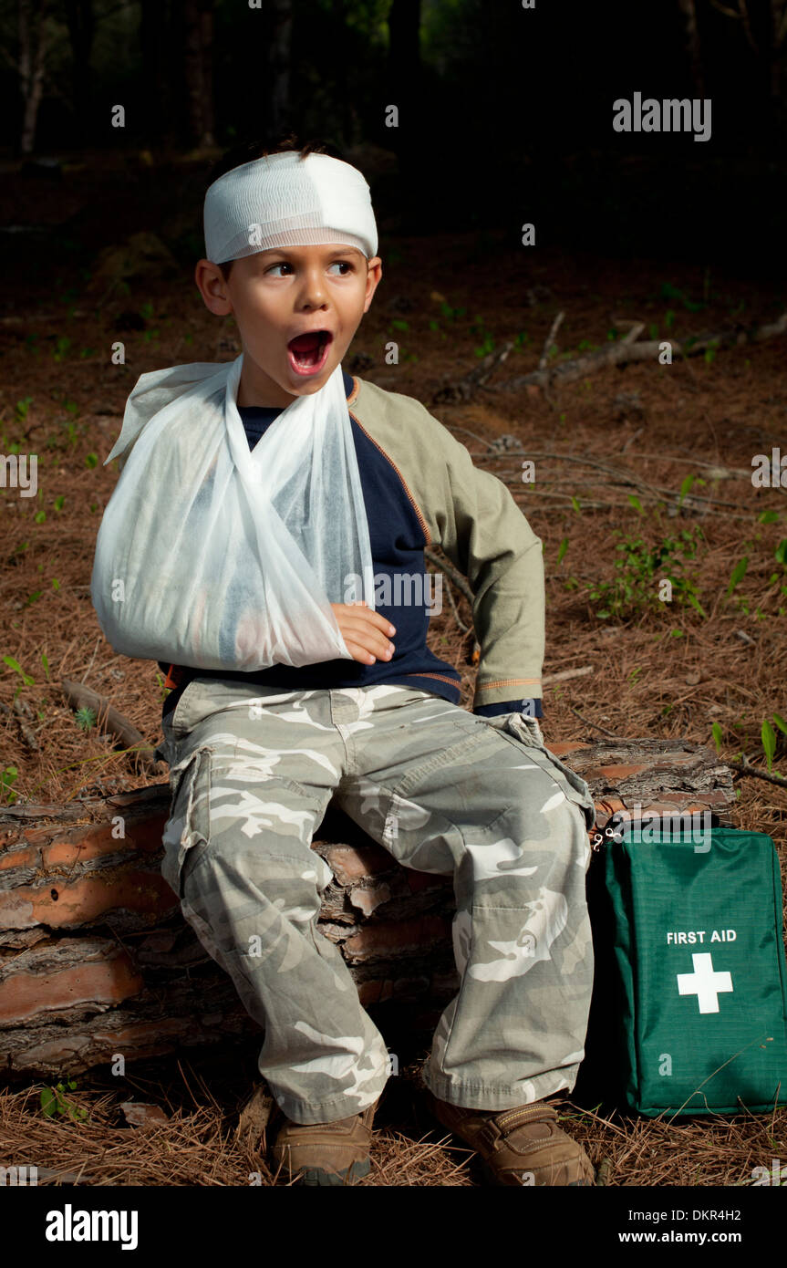 First Aid treatment given to a young boy in the forest, showing an arm ...