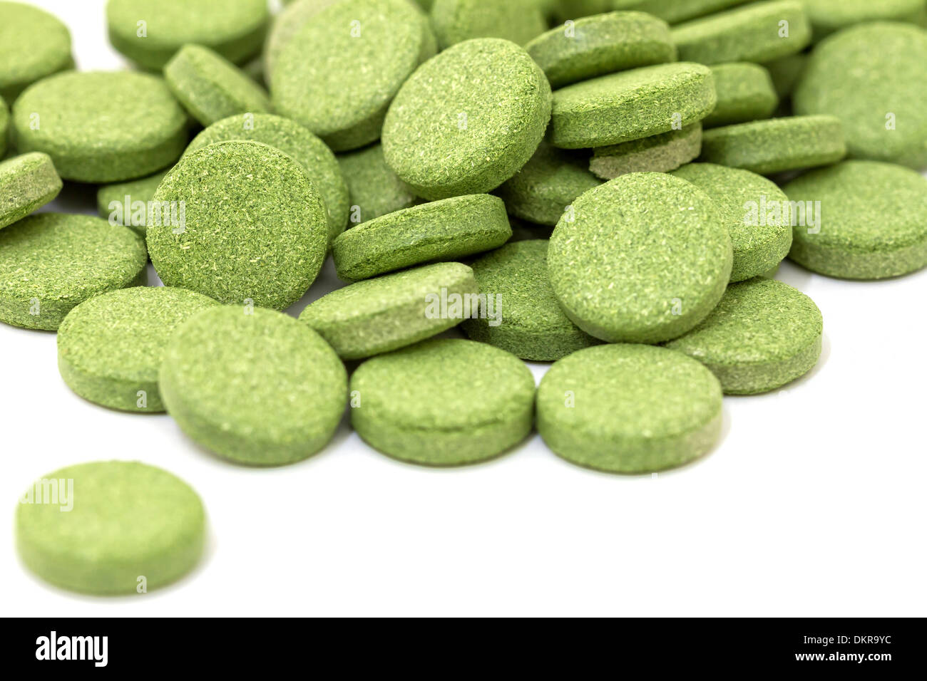 Green chlorophyll tablets on white background Stock Photo - Alamy