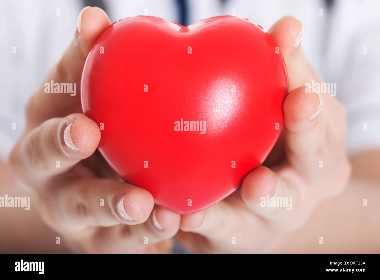Red heart held by a female doctor. Close up Stock Photo - Alamy