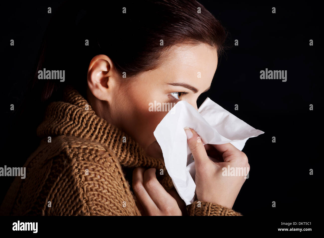 Sad young girl with tissue. Over black background Stock Photo - Alamy