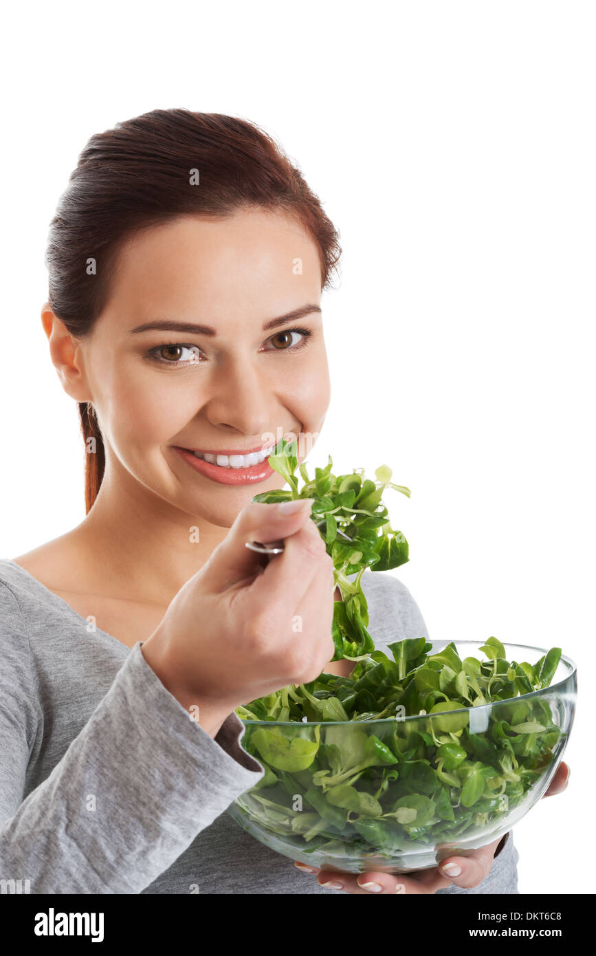 Young casual woman eating lamb's lettuce. Isolated on white Stock Photo ...
