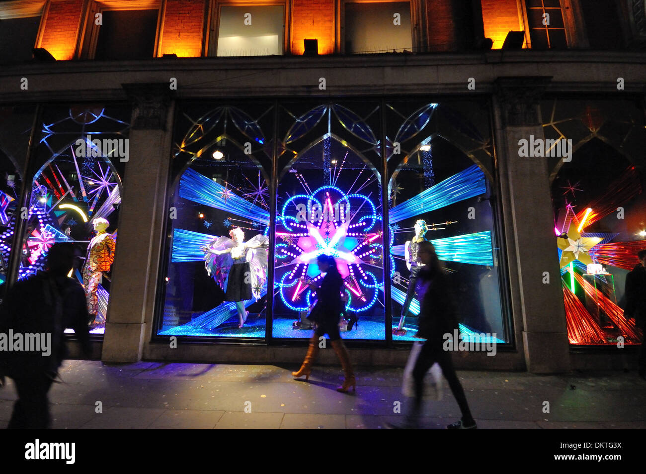 Shoppers walk past window display at Harvey Nichols,London Stock Photo ...