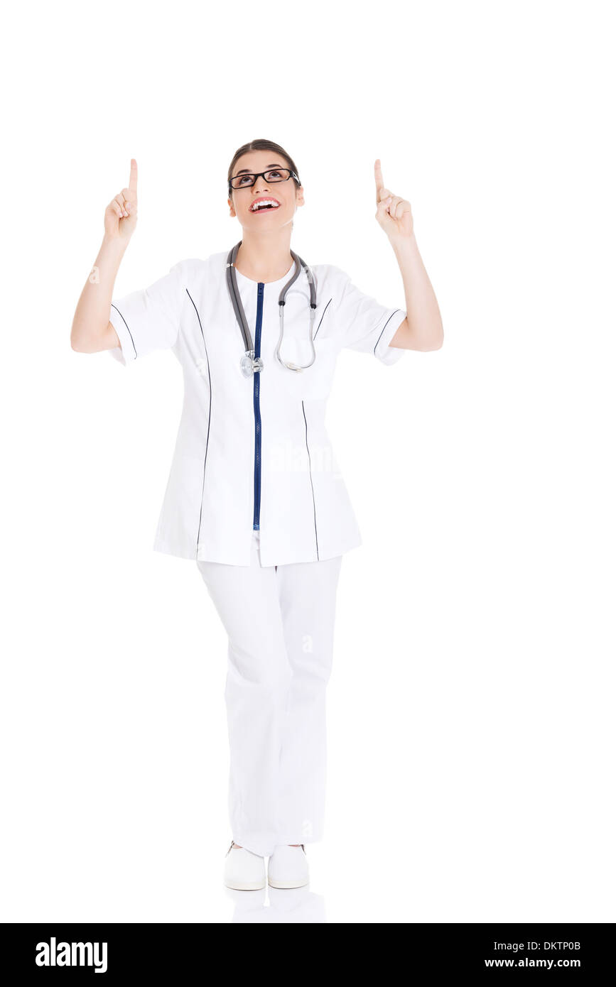 Beautiful young woman doctor pointing up. Isolated on white Stock Photo ...