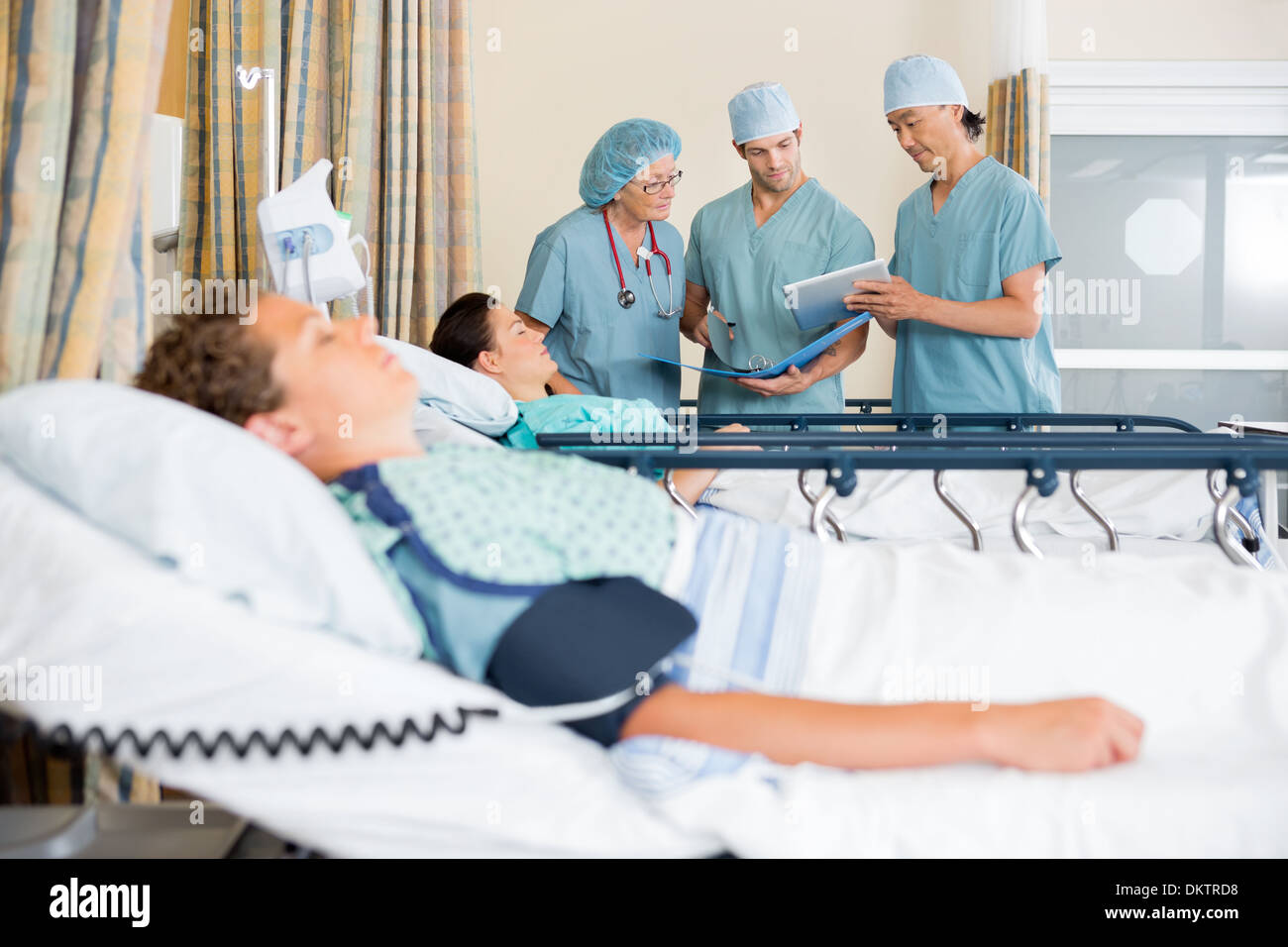 Nurses Discussing Patient's Chart Post Surgery Stock Photo - Alamy
