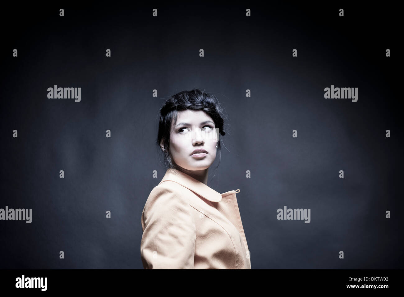 Studio portrait of young woman wearing yellow coat Stock Photo - Alamy