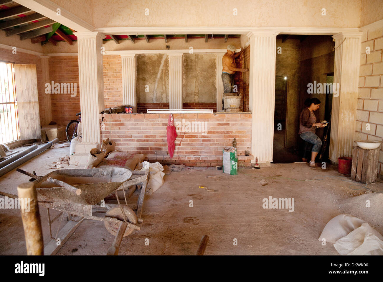Builders doing building and restoration work inside a house, Vinales ...