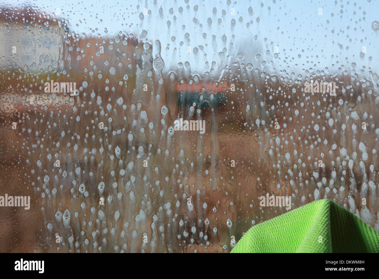 Drops on the windowpane, cleaning window with spray detergent. Glass ...