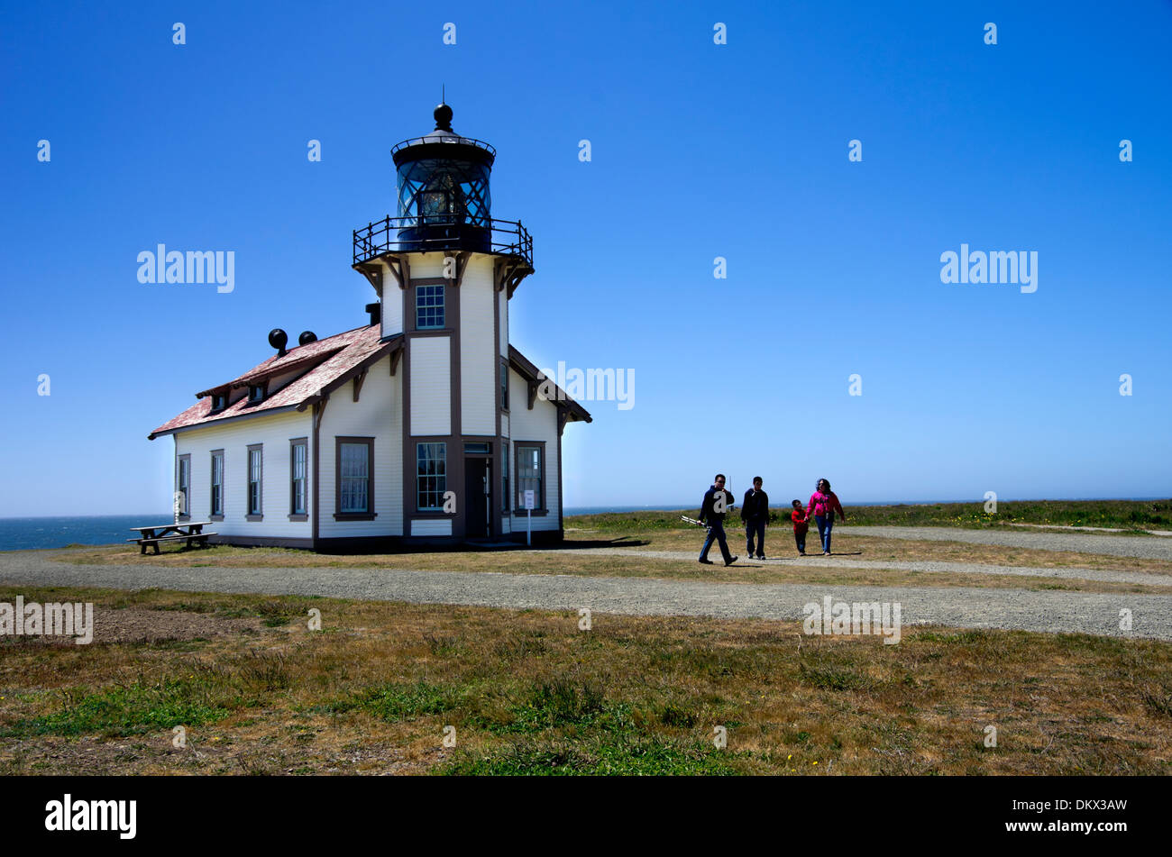 Pt. Arena Lighthouse, two men one woman and child walk away from ...