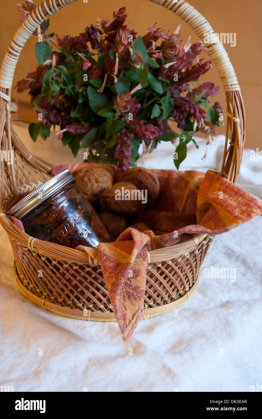 home grown food in basket on white cloth with flowers in background ...