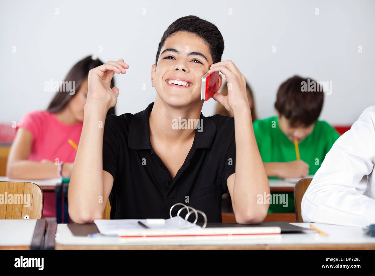 Teenage Male Student Using Phone In Classroom Stock Photo - Alamy