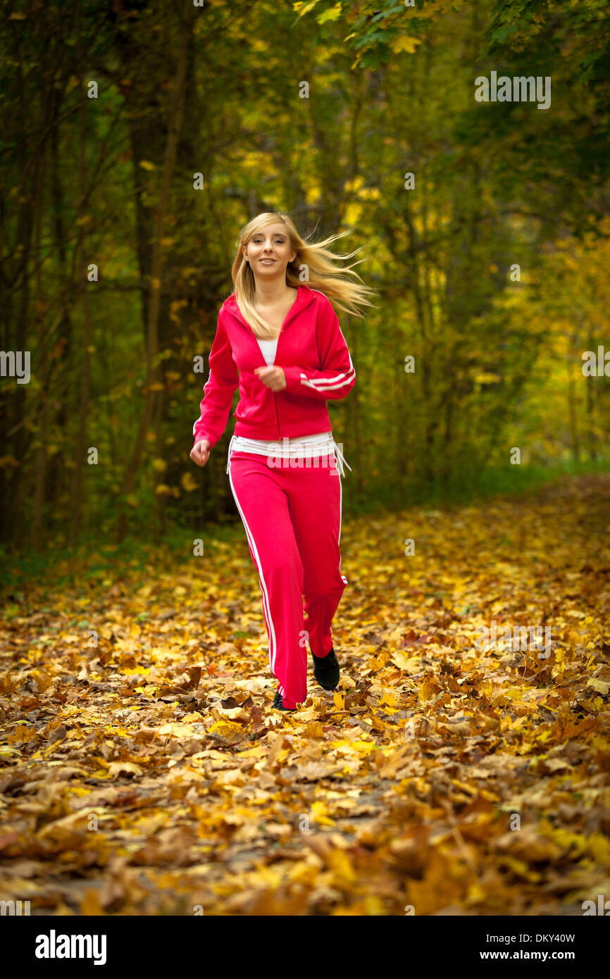 Woman running in autumn fall forest. Female runner training outdoor ...