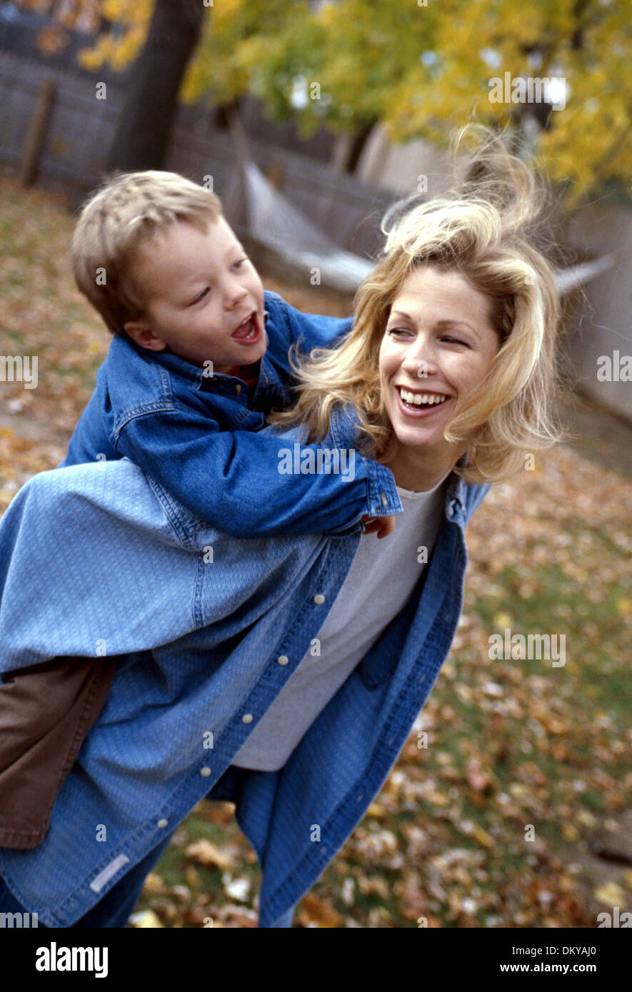 MOTHER GIVING SON PIGGYBACK RIDE WWOMAN SON FUN HAPPY PIGGYBACK OUTSIDE ...