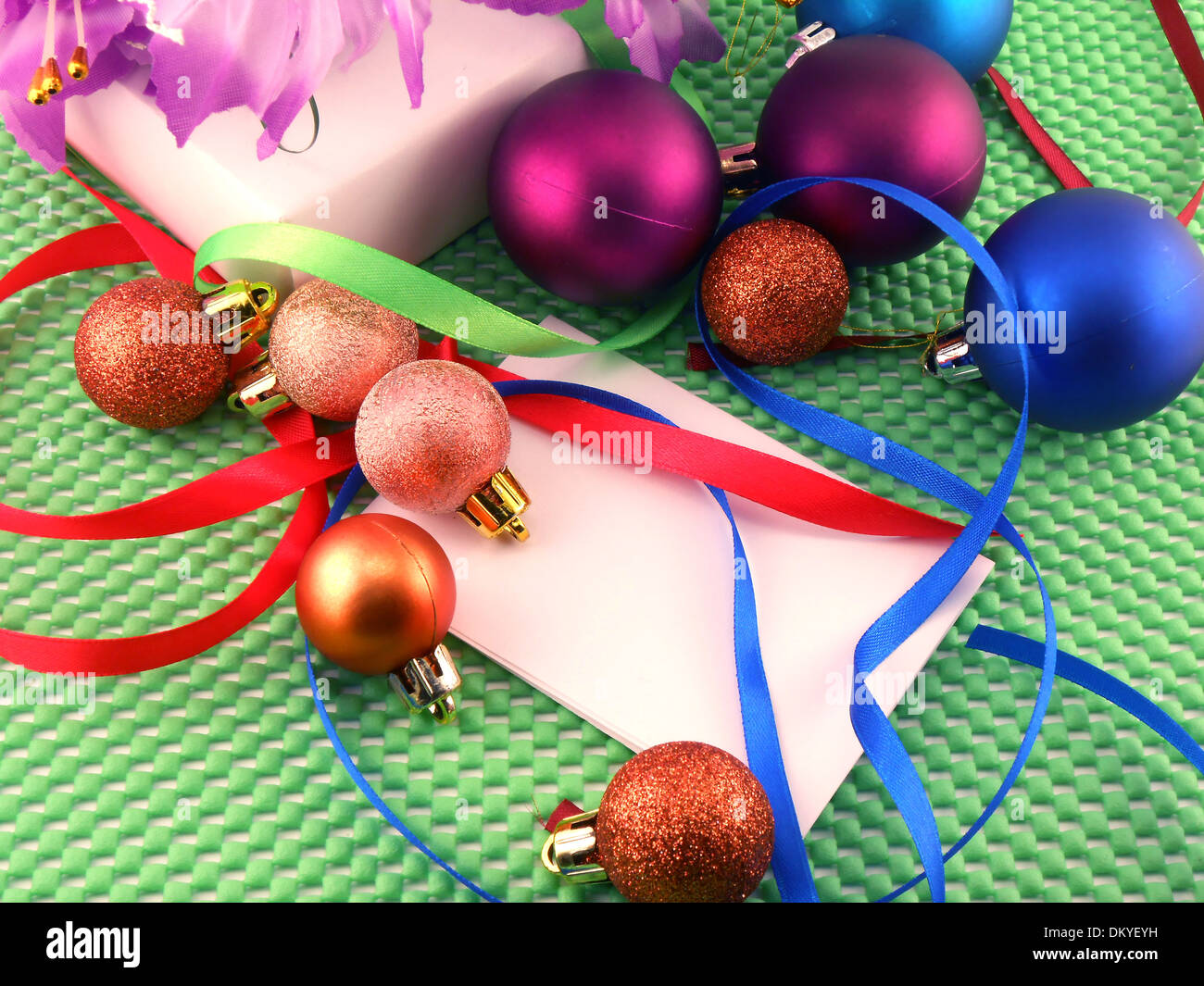 A white gift with a green ribbon and new year balls Stock Photo - Alamy