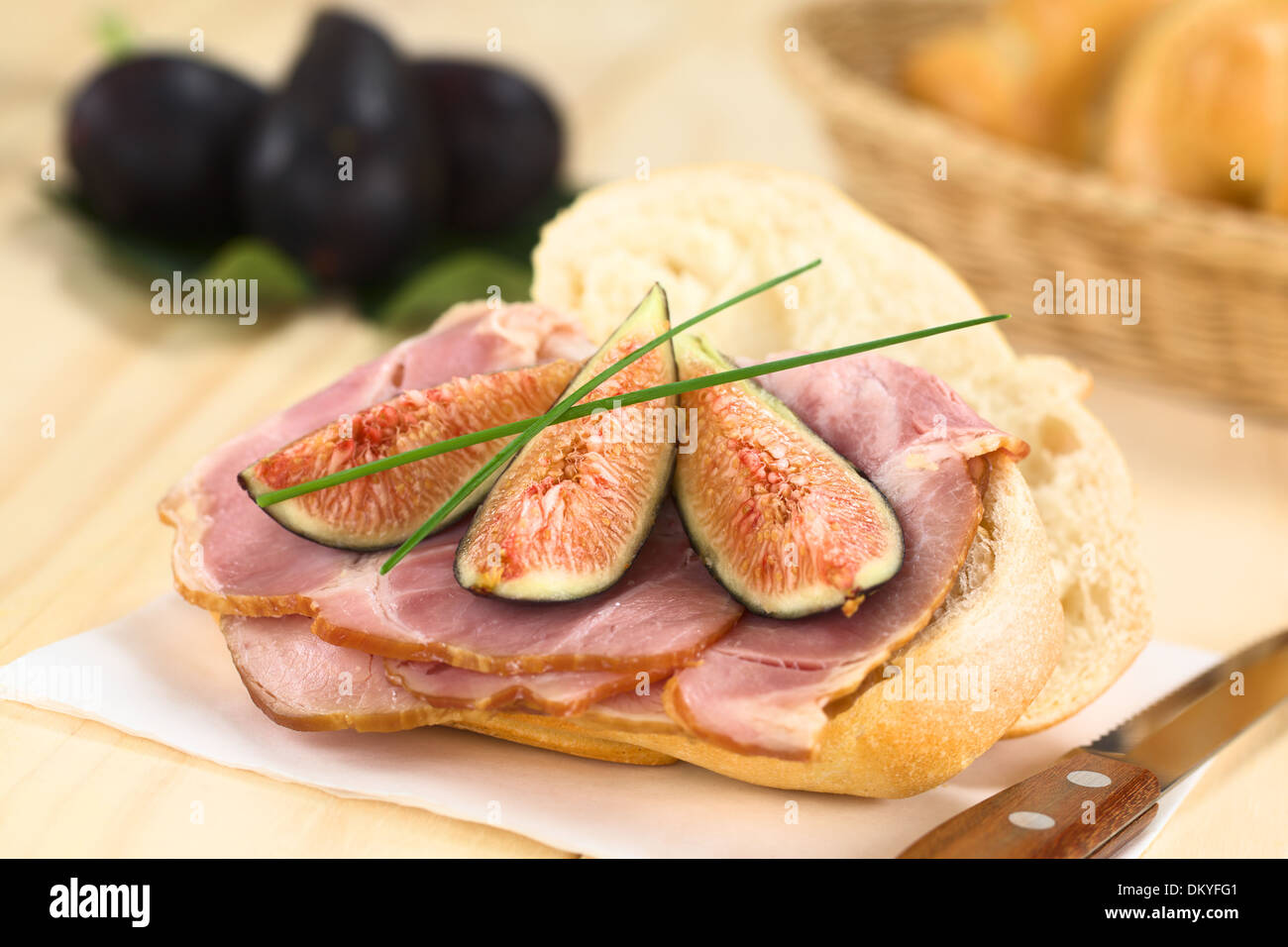 Fresh fig slices on smoked ham sandwich garnished with chives on ...