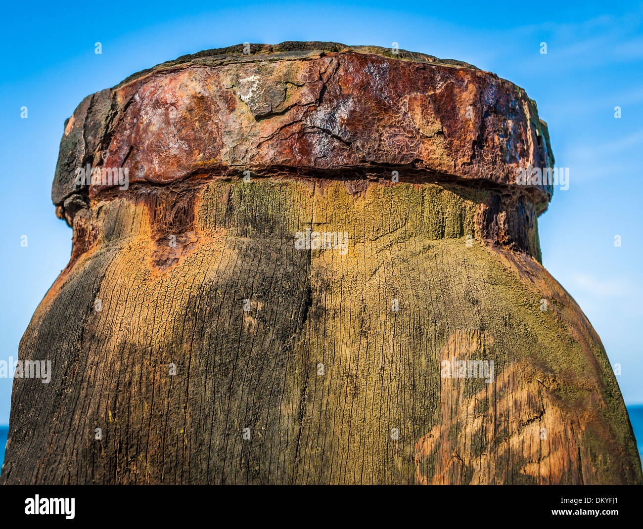 Weathered wooden post with rusty iron capping Stock Photo - Alamy