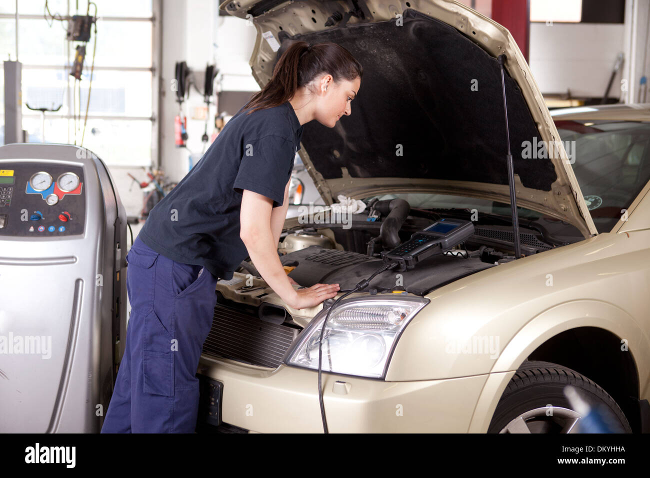 A woman mechanic tuning a car with diagnostic equipment Stock Photo - Alamy
