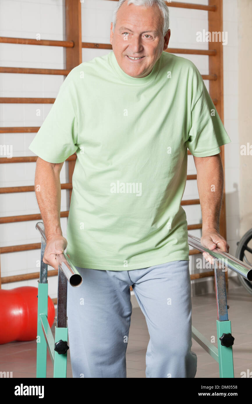 Man Walking With The Help Of Support Bars Stock Photo - Alamy
