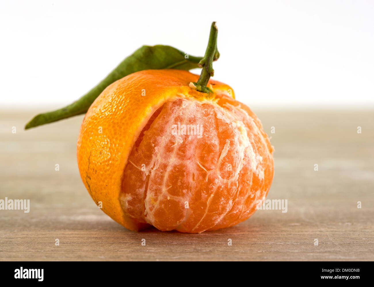 single orange mandarin with green leaves Stock Photo - Alamy