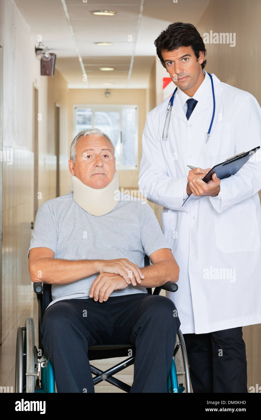 Doctor Standing By Patient On Wheel Chair Stock Photo - Alamy