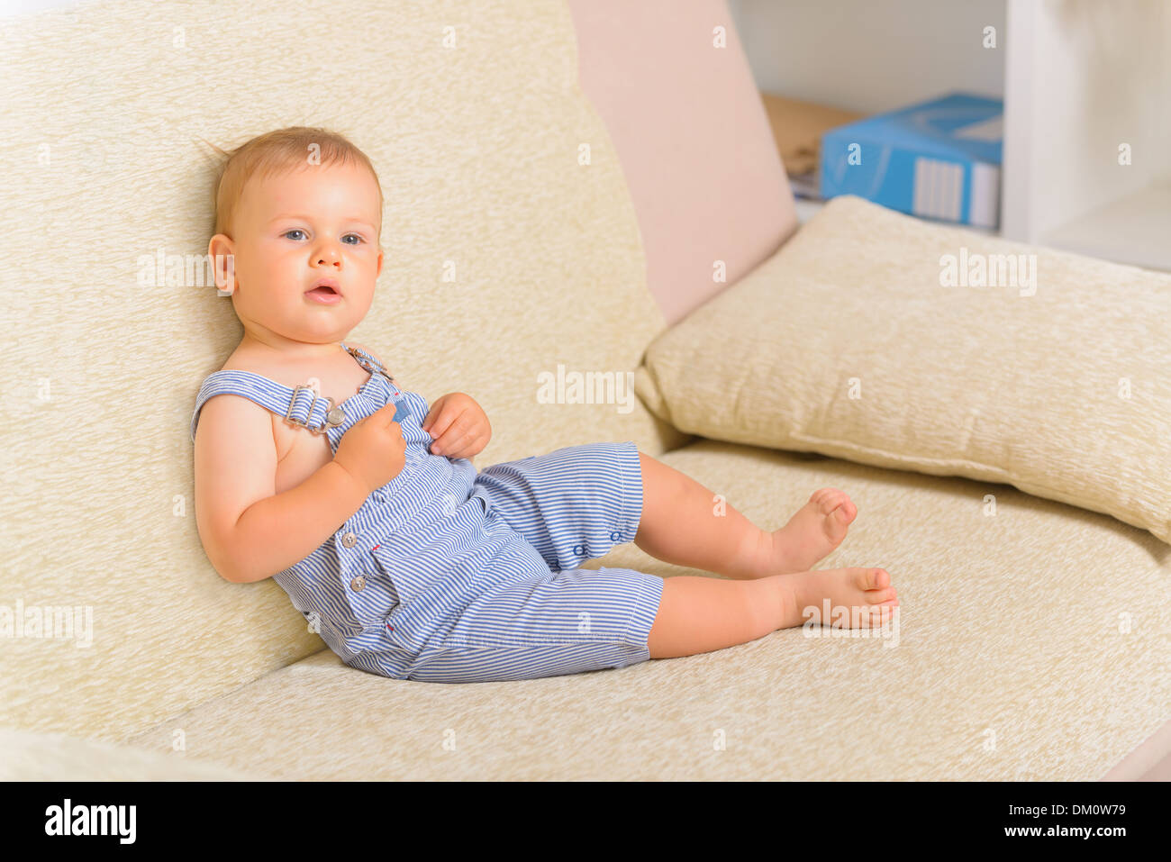 Cheerful baby boy sitting on the couch Stock Photo - Alamy