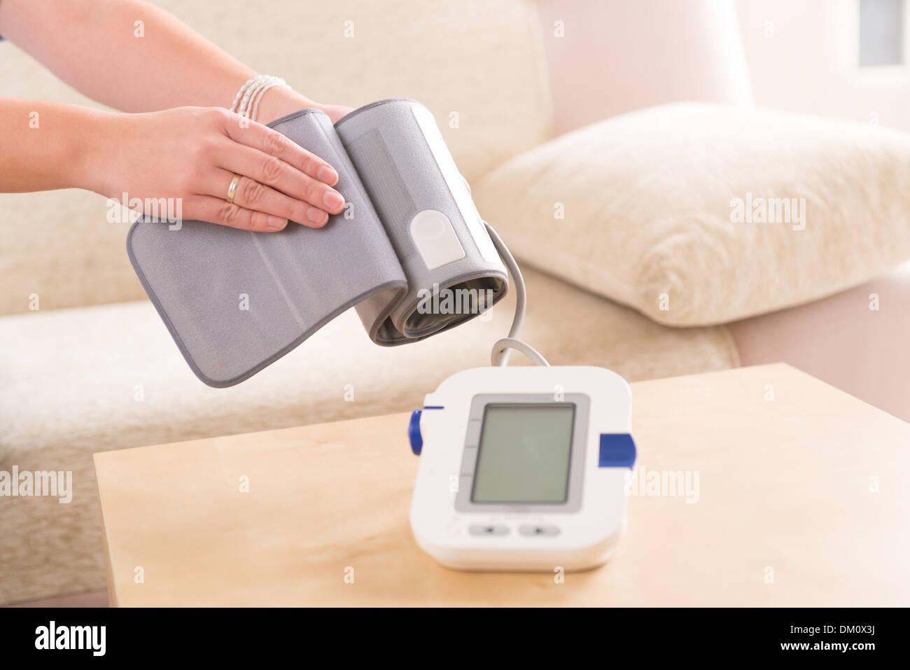 Women's hands with blood pressure monitor cuff Stock Photo - Alamy