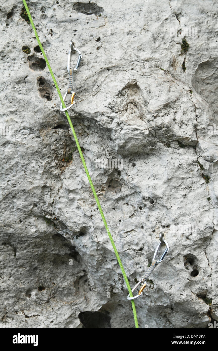 Rock climbing equipment - a quickdraws and rope on a limestone wall ...