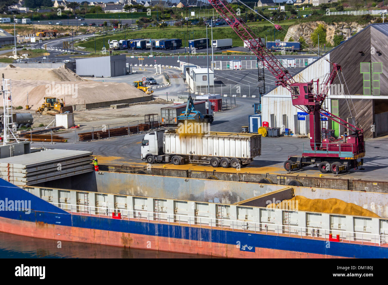 Dock side, crane filling large lorry with sand Stock Photo - Alamy