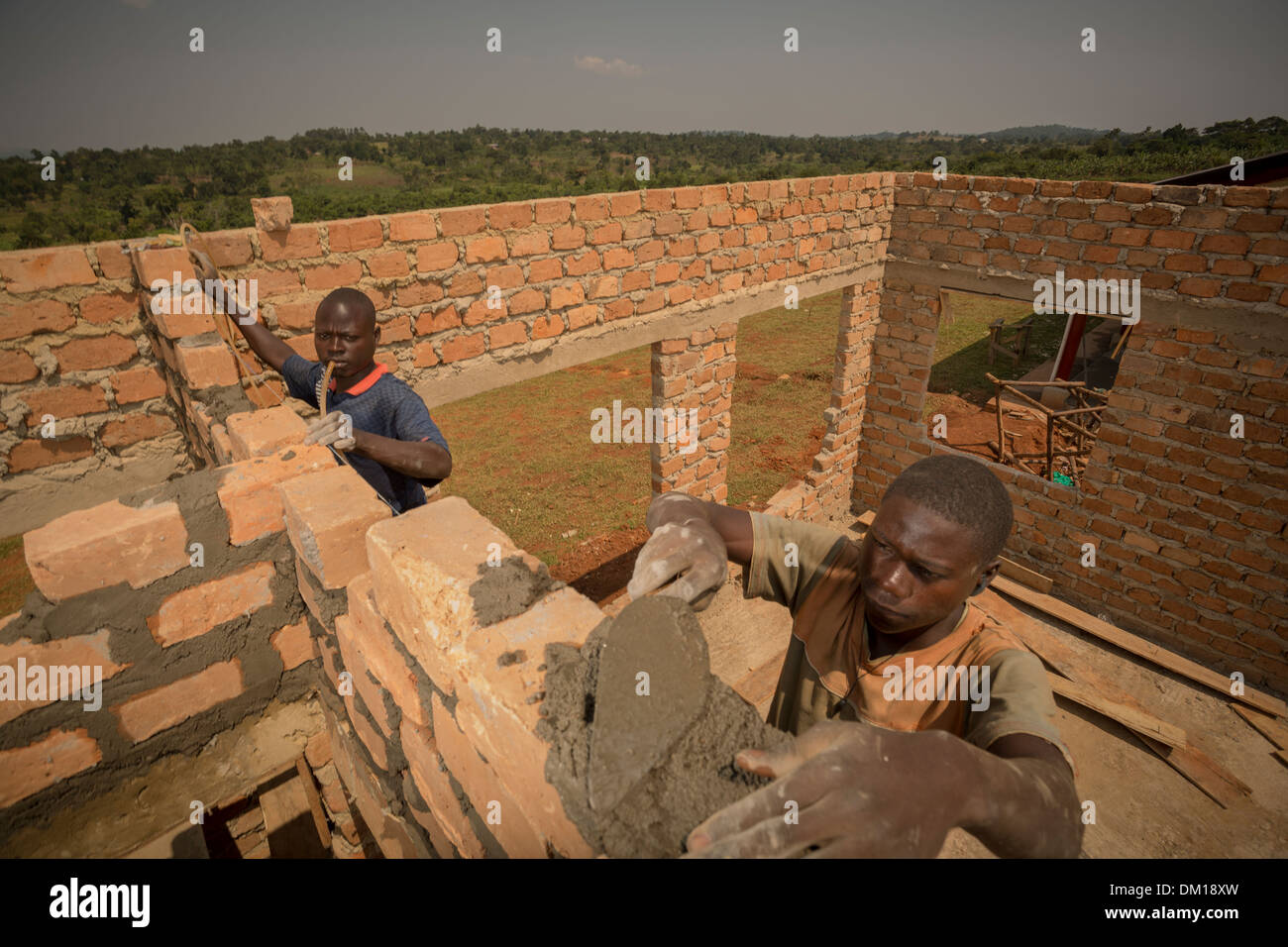 Construction workers build a new warehouse on the outskirts of Kampala ...
