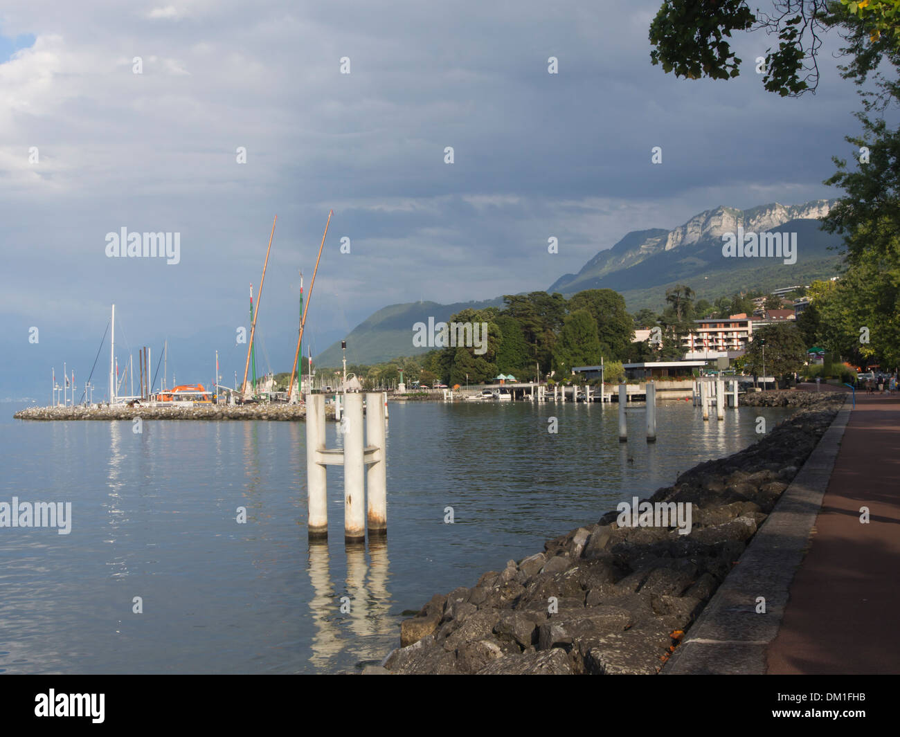 Lake Geneva waterfront footpath with pleasure boat harbour in evening ...
