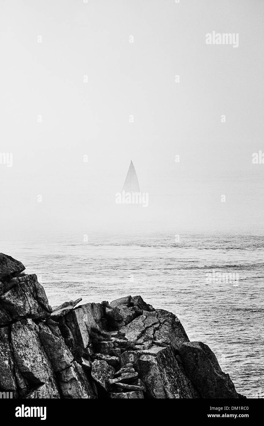 Sailboat disappearing into the sea mist at Pointe du Raz Stock Photo ...