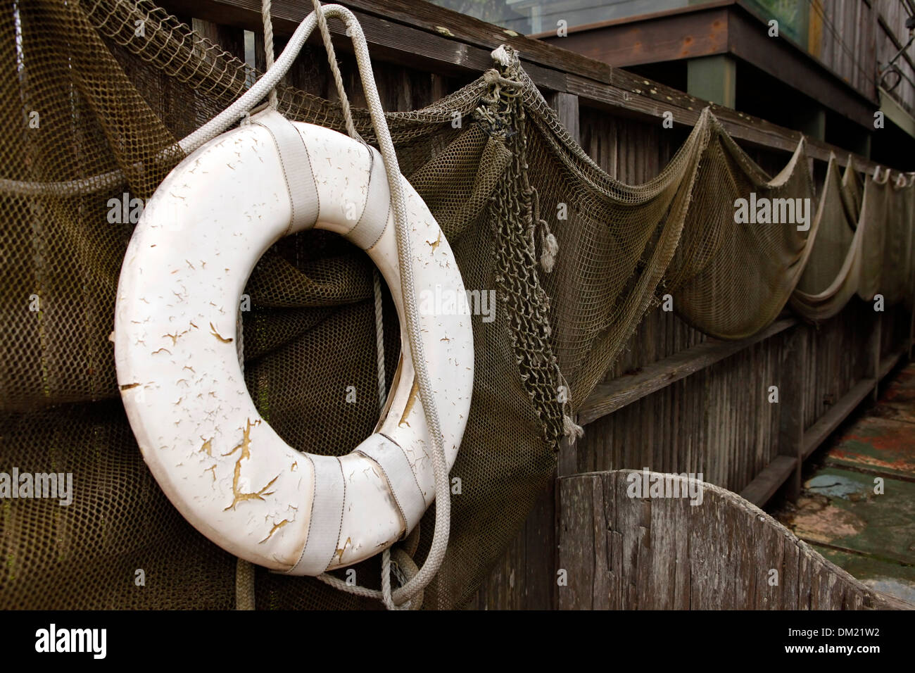 Old net and old lifebuoy are hanging on land Stock Photo - Alamy