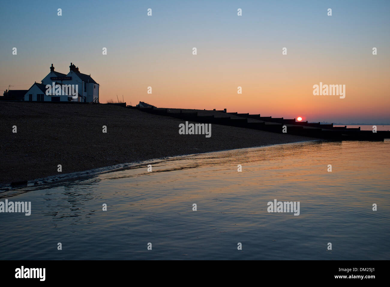 The setting sun glows in the sky near the Old Neptune pub Stock Photo ...