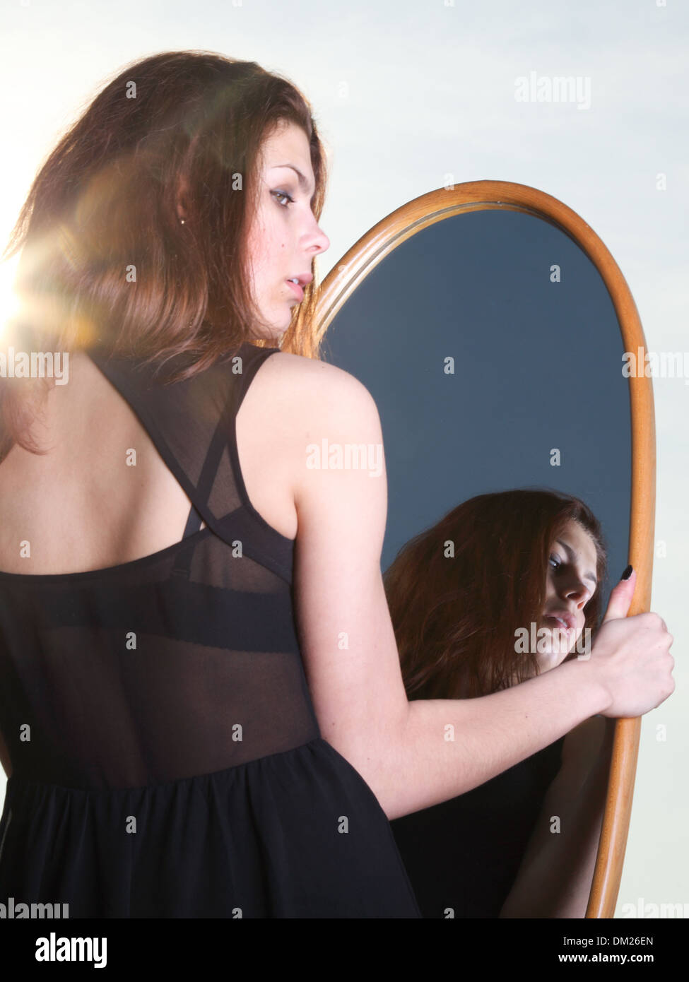 thoughtful young woman looks at the reflection in the mirror - solitude ...