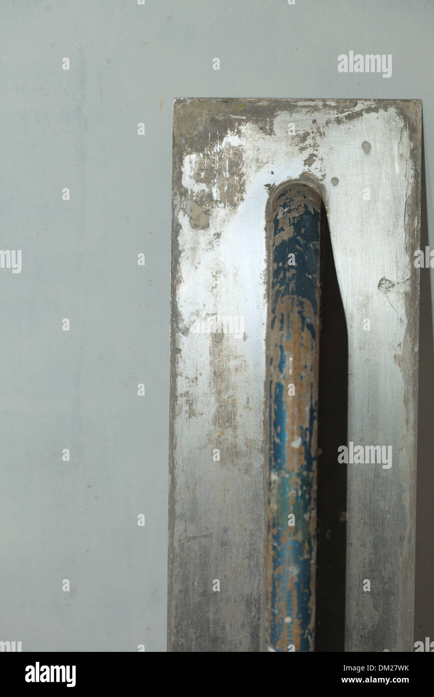 Old dirty trowel used for masonry on rough unfinished concrete surface ...