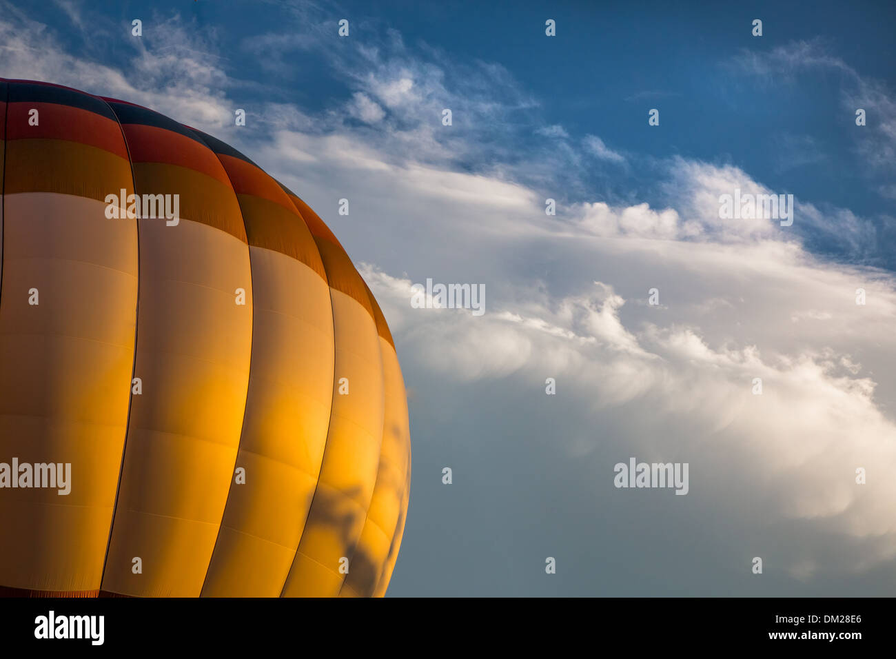 A hot air balloon the warm light of the setting sun with storm clouds ...