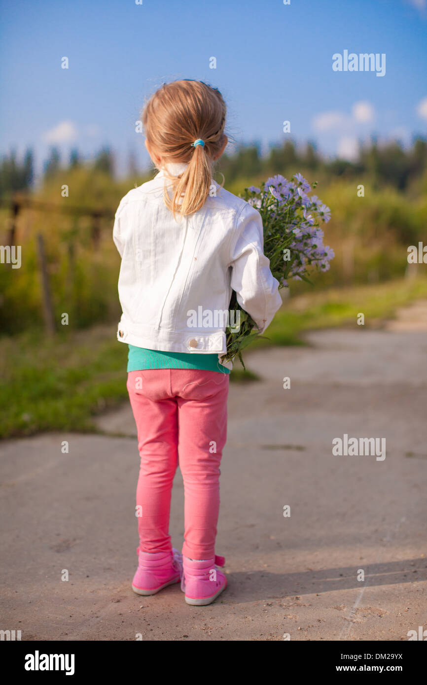 Little cute girl walking with a bouquet of flowers Stock Photo - Alamy